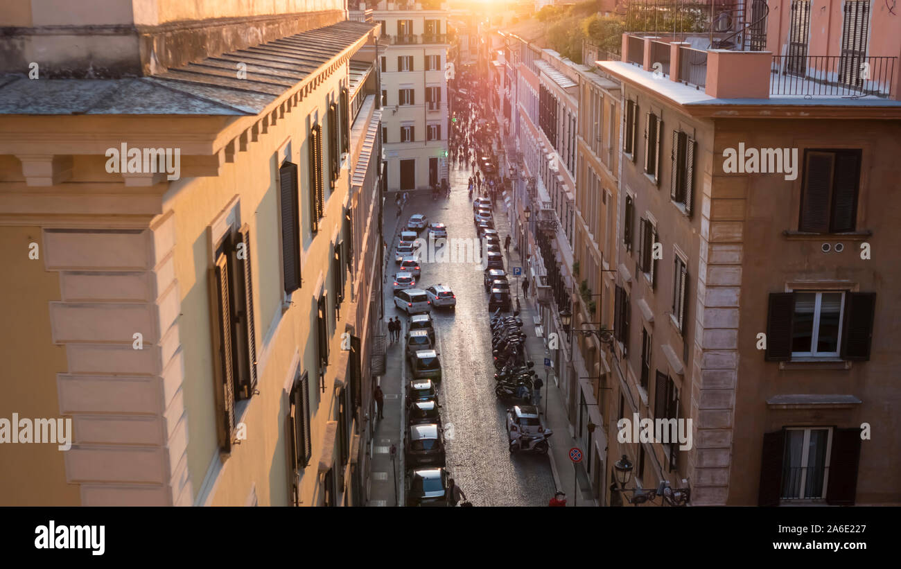 Setting sun on a busy street in the historic center of the city of Rome ...