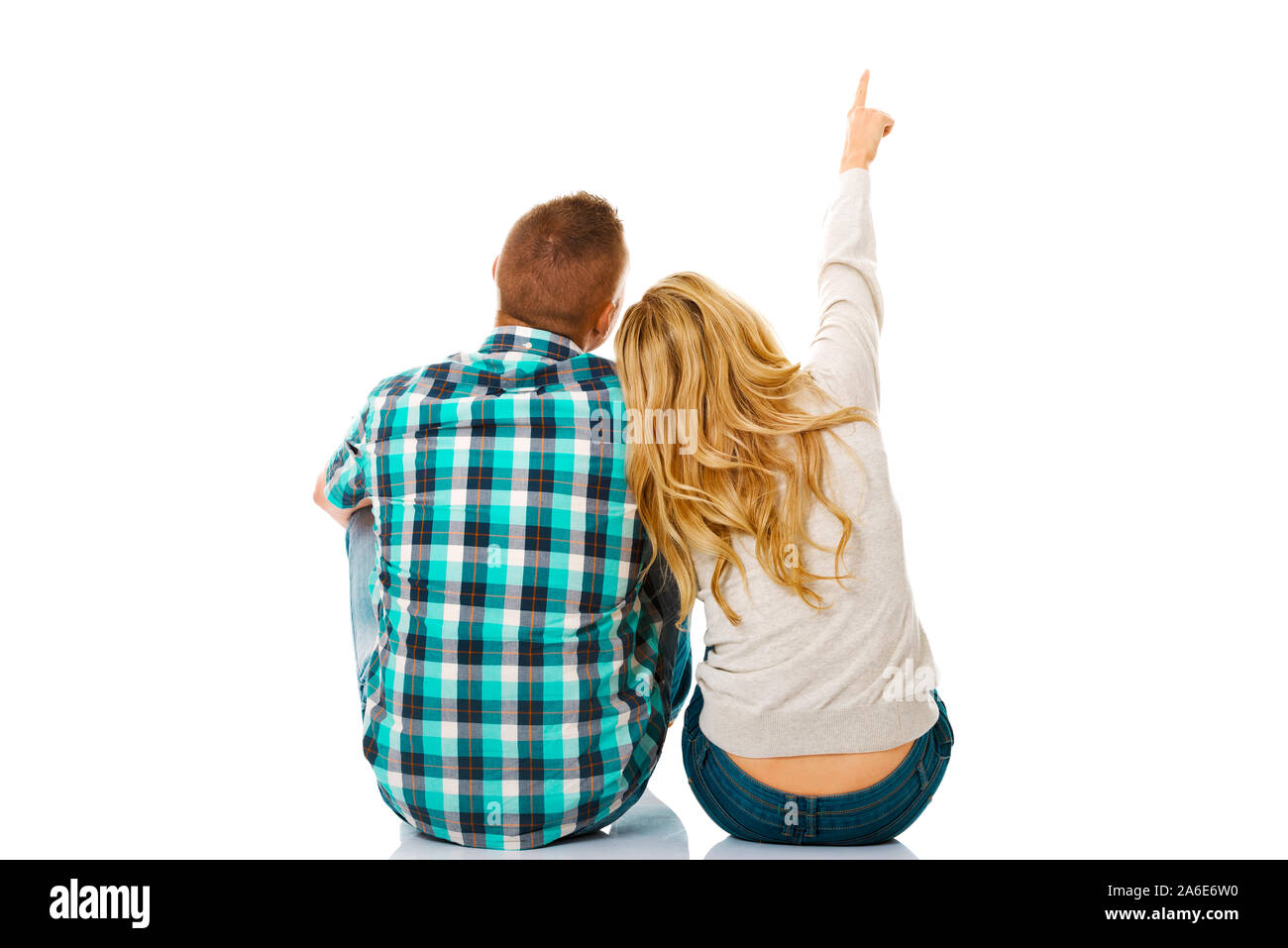 Back view of couple sitting on white background and showing copy space ...