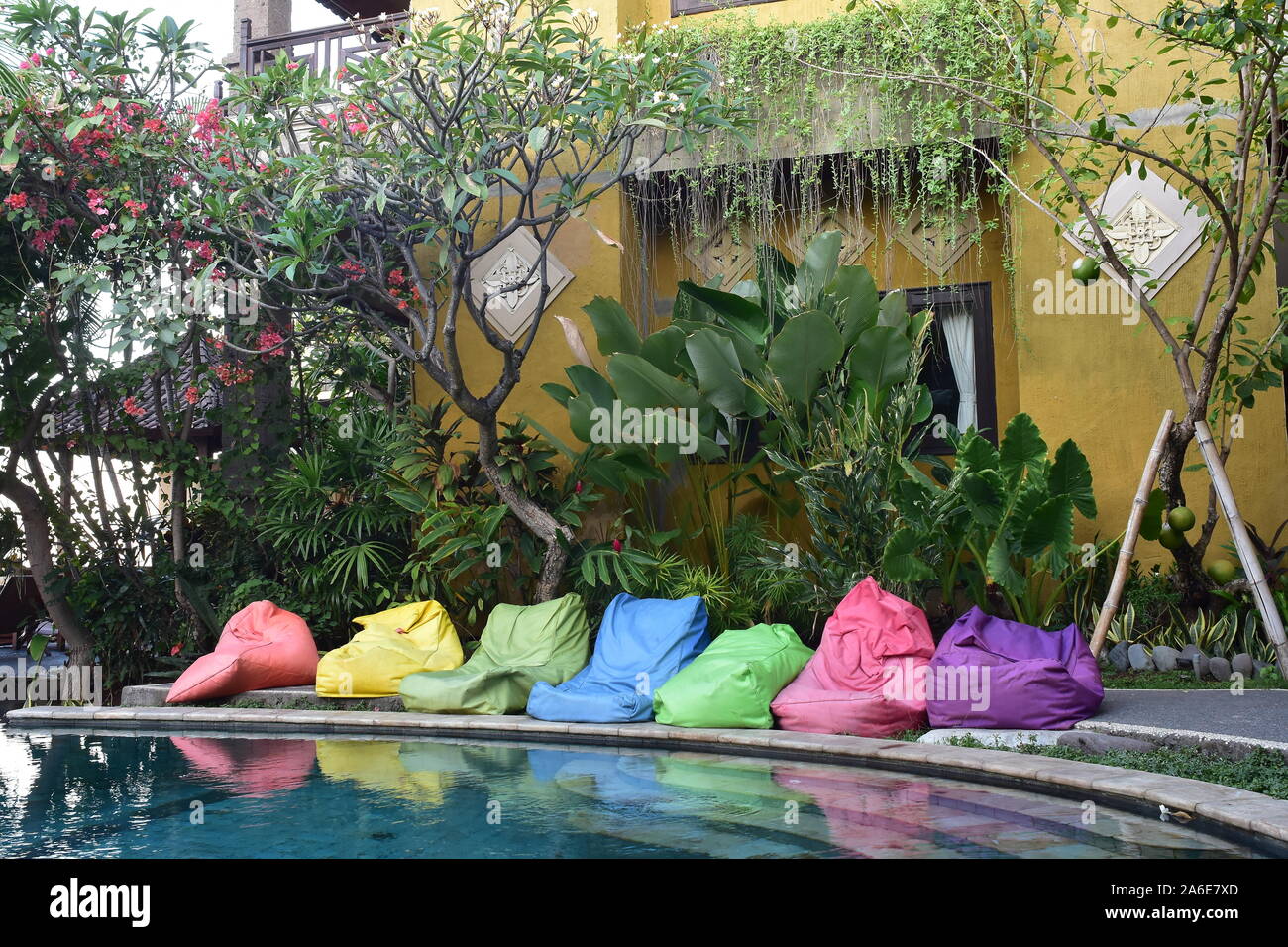 Row of colorful cushions along edge of pool inside tropical resort in ...