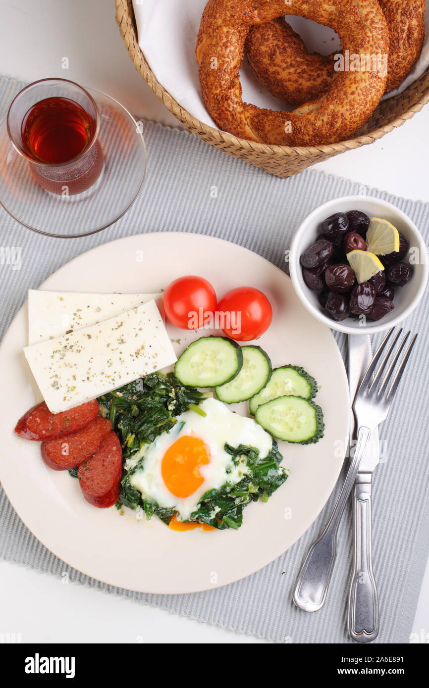 Turkish breakfast with fried egg, sucuk, cheese, vegetables, simit, and ...