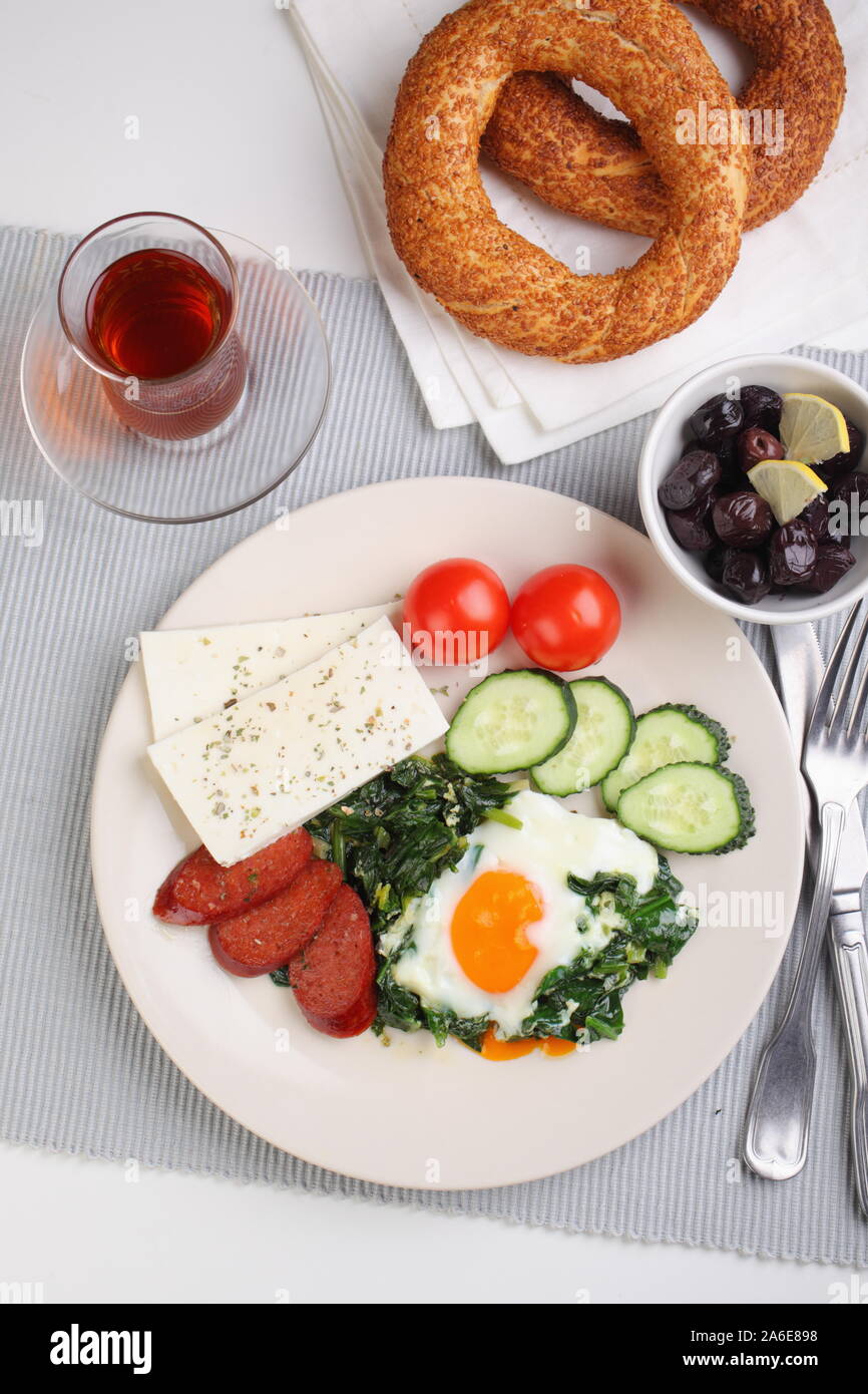 Turkish breakfast with fried egg, sucuk, cheese, vegetables, simit, and ...