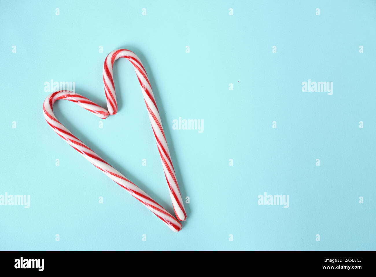 Candy cane heart on cyan background Stock Photo - Alamy