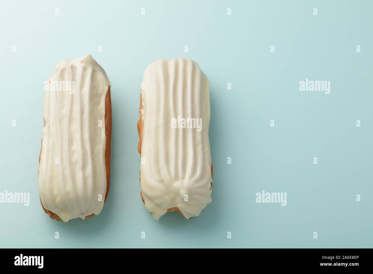 Eclairs with White Chocolate Glaze on duck egg blue background. Pastel ...