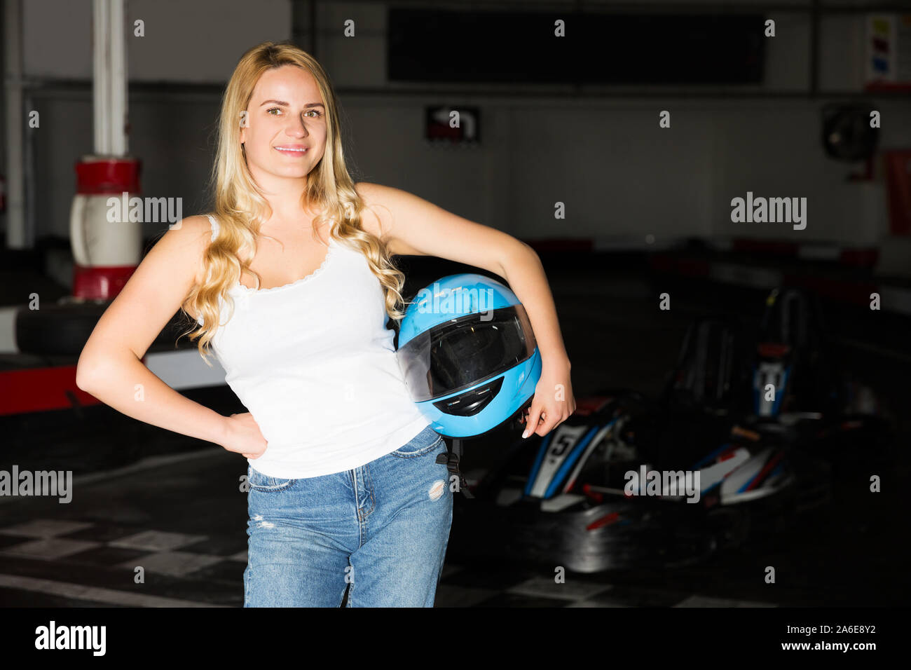 happy young female model posing near racing cars at cart circuit Stock ...
