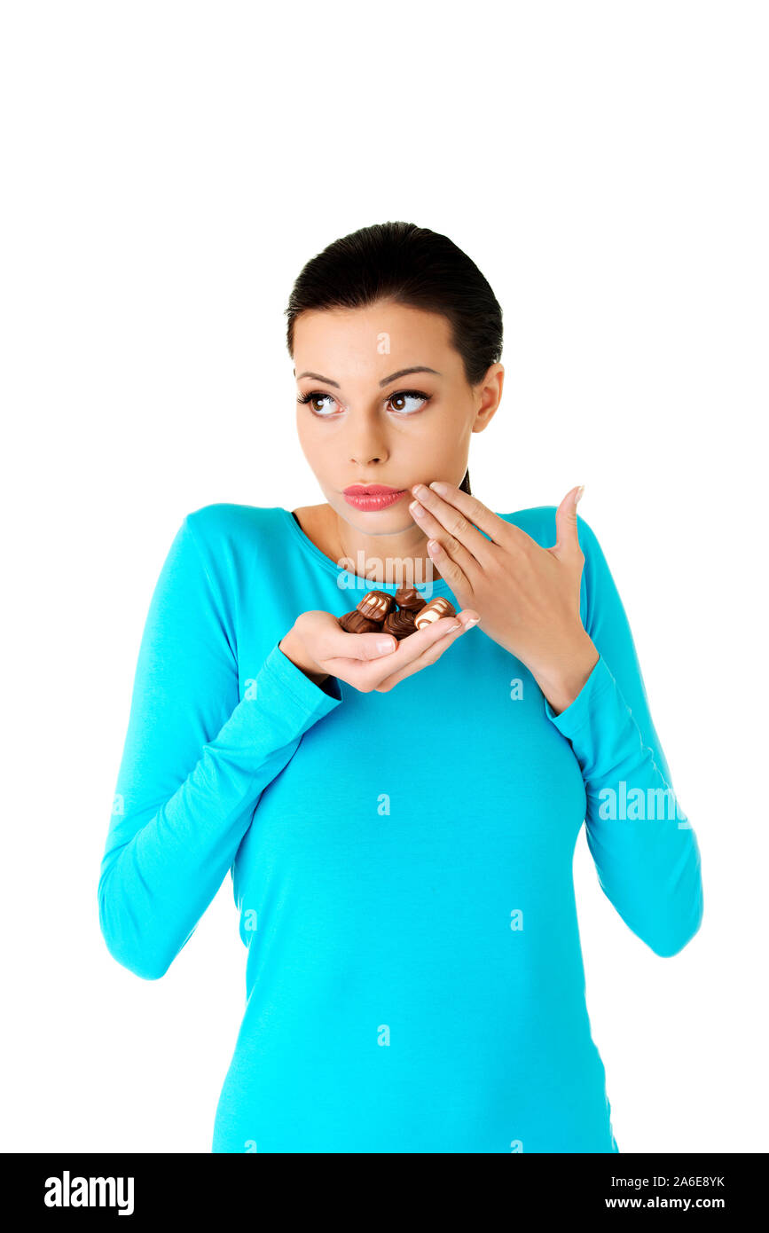 Woman is snacking chocolates. She eating sweets with enjoy for humor ...