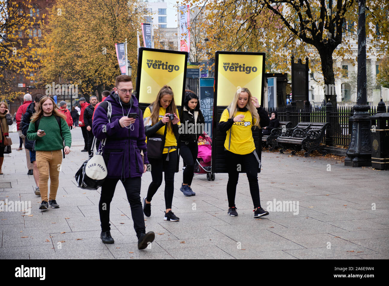 Two young females carrying walking advertising billboard on their ...