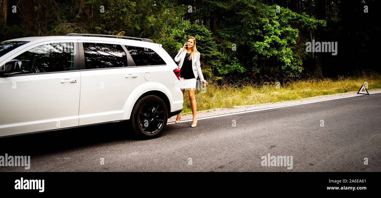 Worried woman caling for help, car assistance or insurance. Car is ...