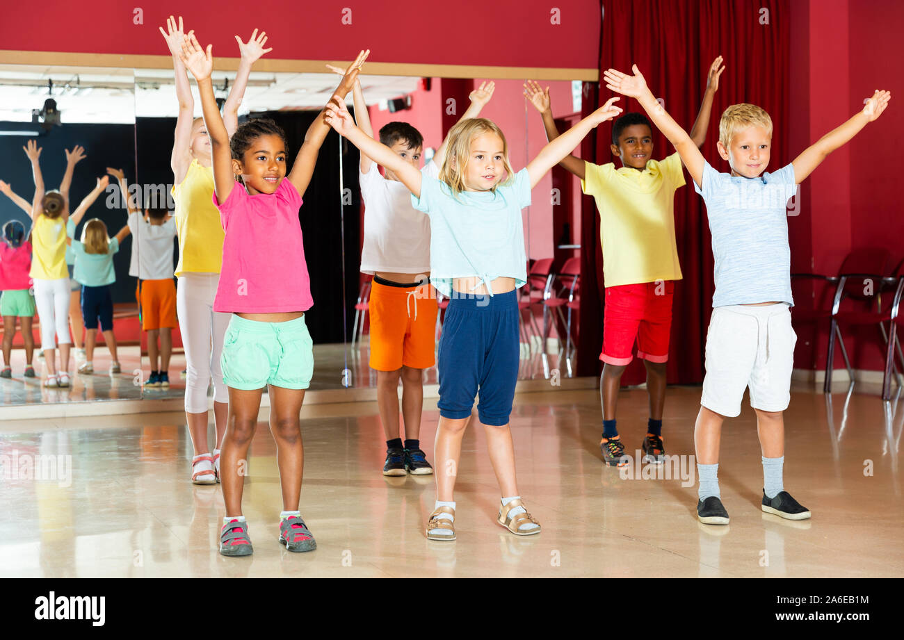 Children jumping while studying modern style dance in class indoors ...