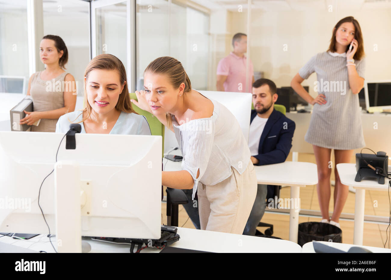business woman explaining something to female coworker, pointing at ...