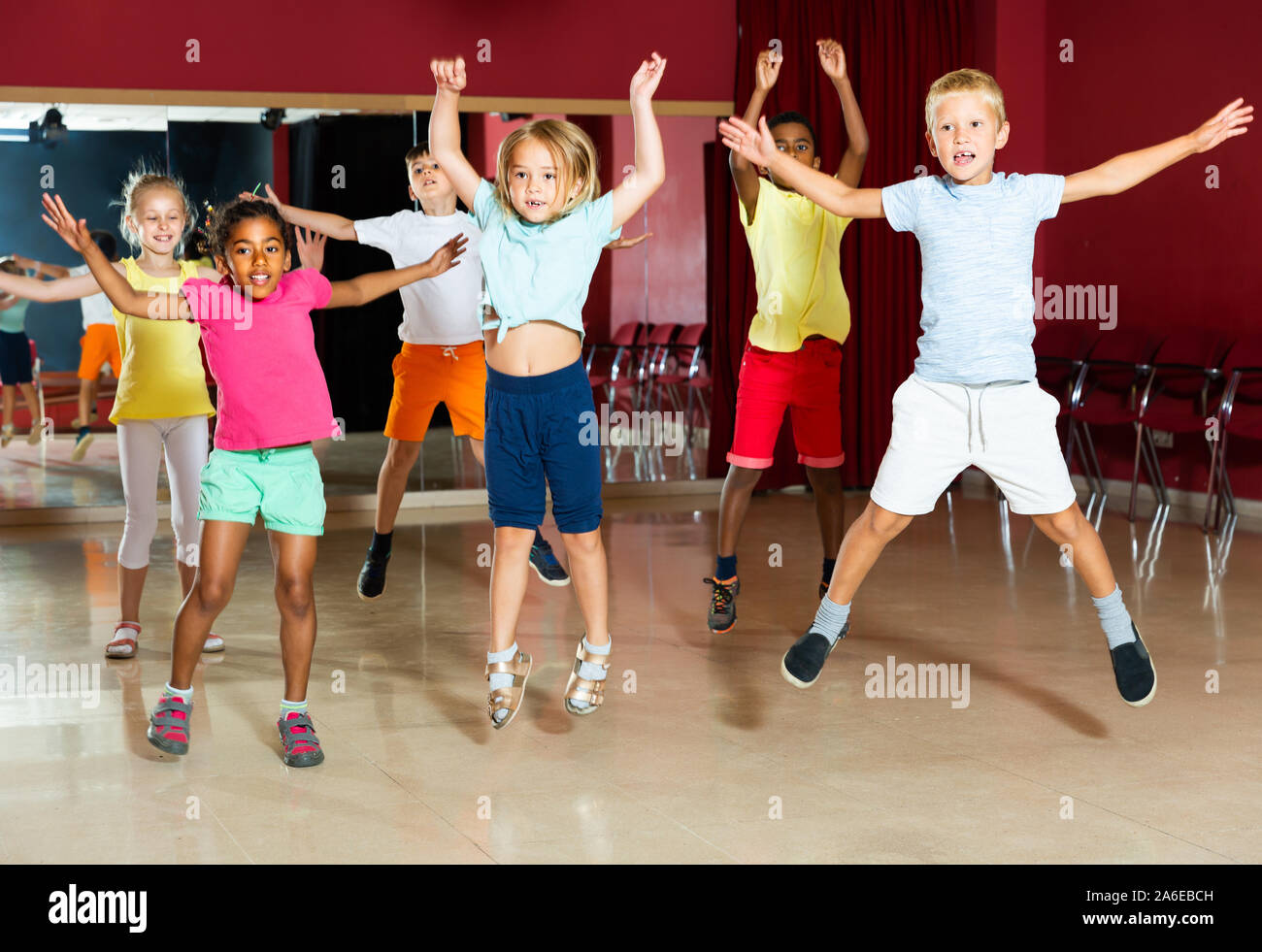 Happy children jumping while studying modern style dance in class ...