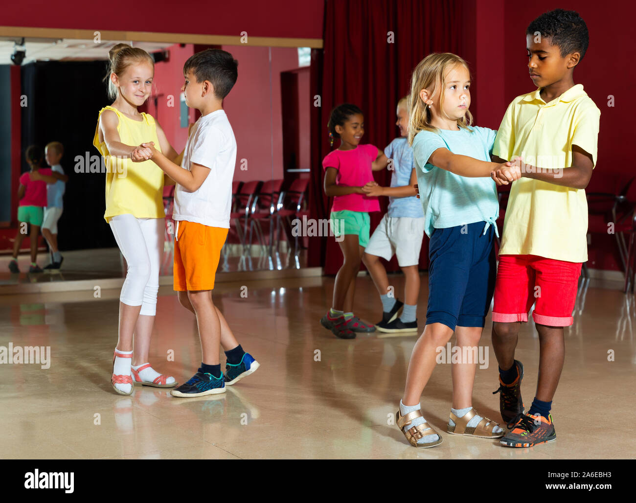 Group of cheerful children dancing salsa dance in modern studio Stock ...