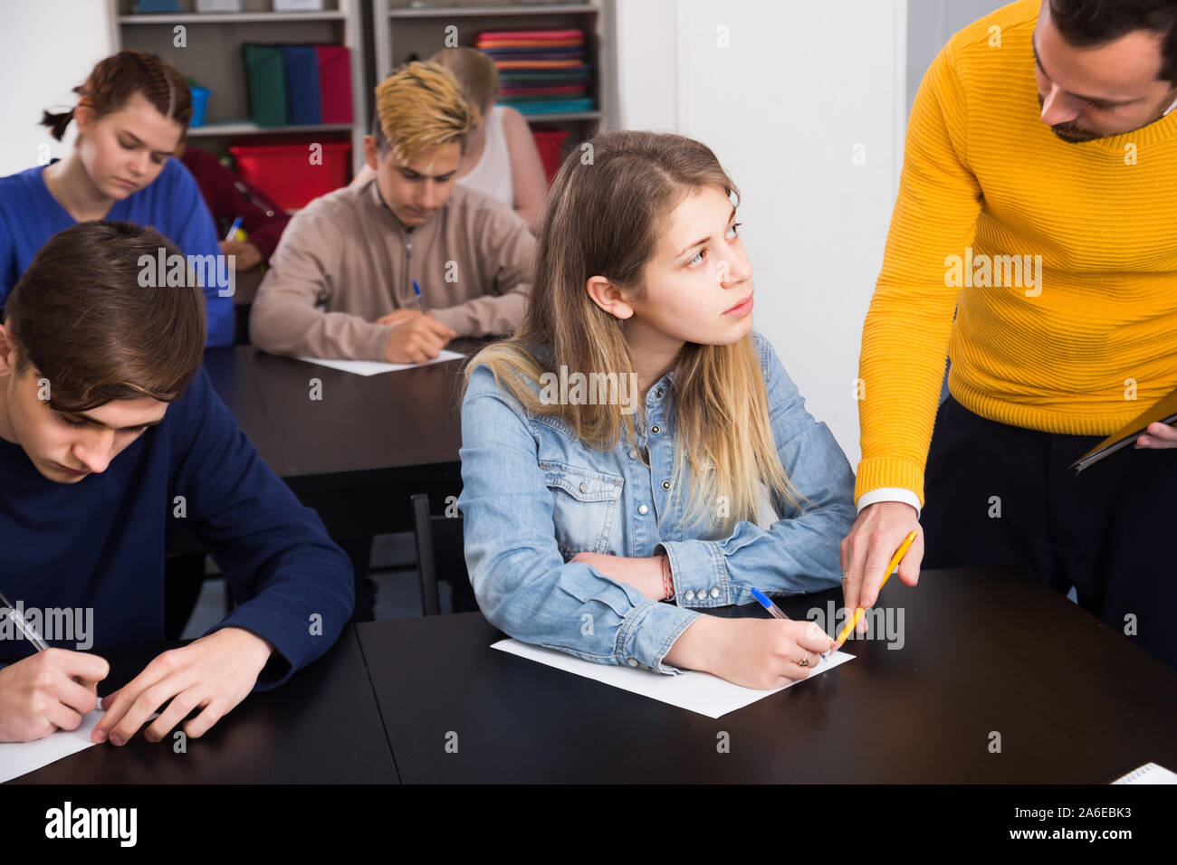 positive spanish male teacher clearing up complicated issue to pupil ...