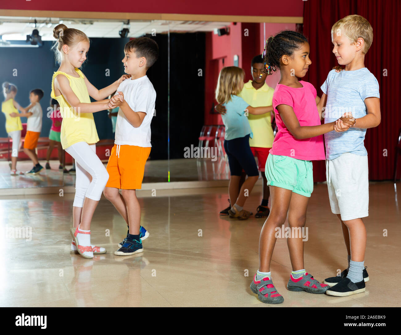 Group of joyful children dancing salsa dance in modern studio Stock ...