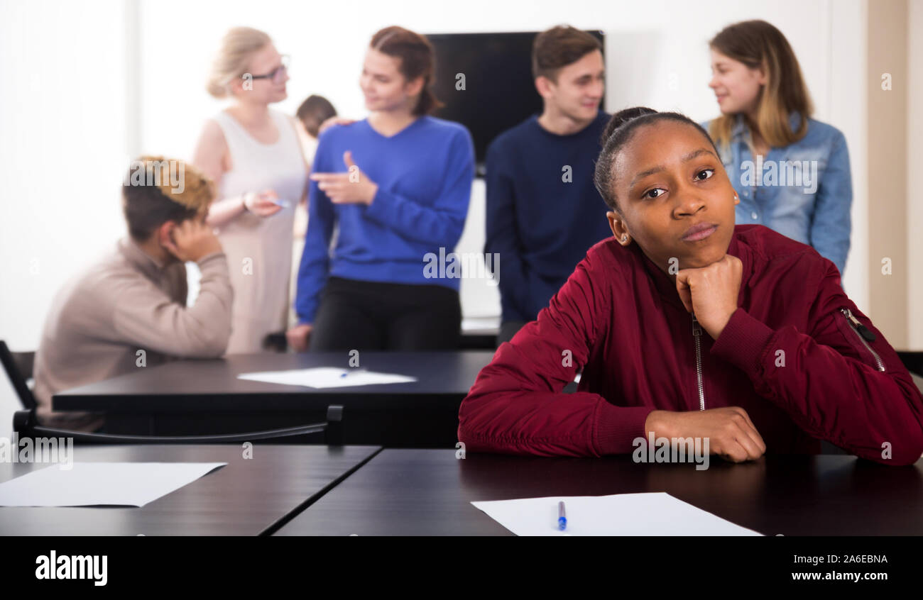 Young new girl student being shy among classmates at recess in school ...