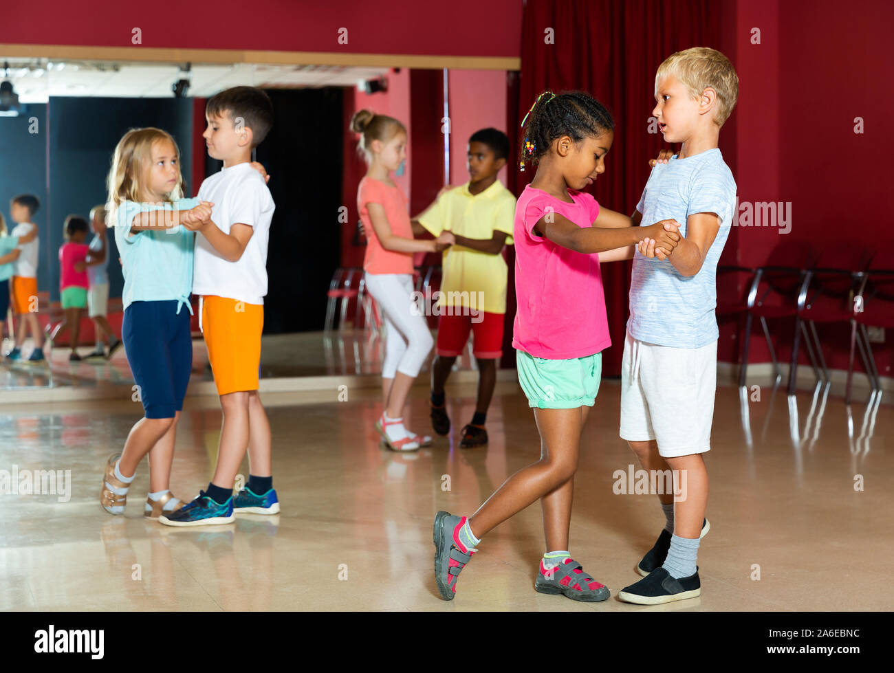 Group of ordinary kids dancing salsa dance in modern studio Stock Photo ...