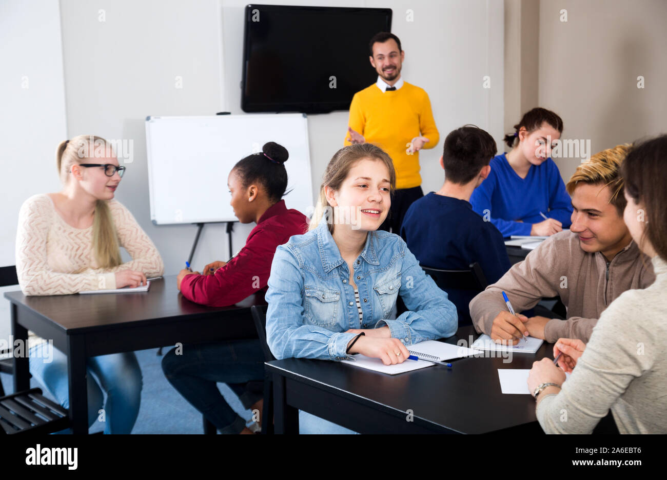 Friendly classmates working in groups to complete task during class ...