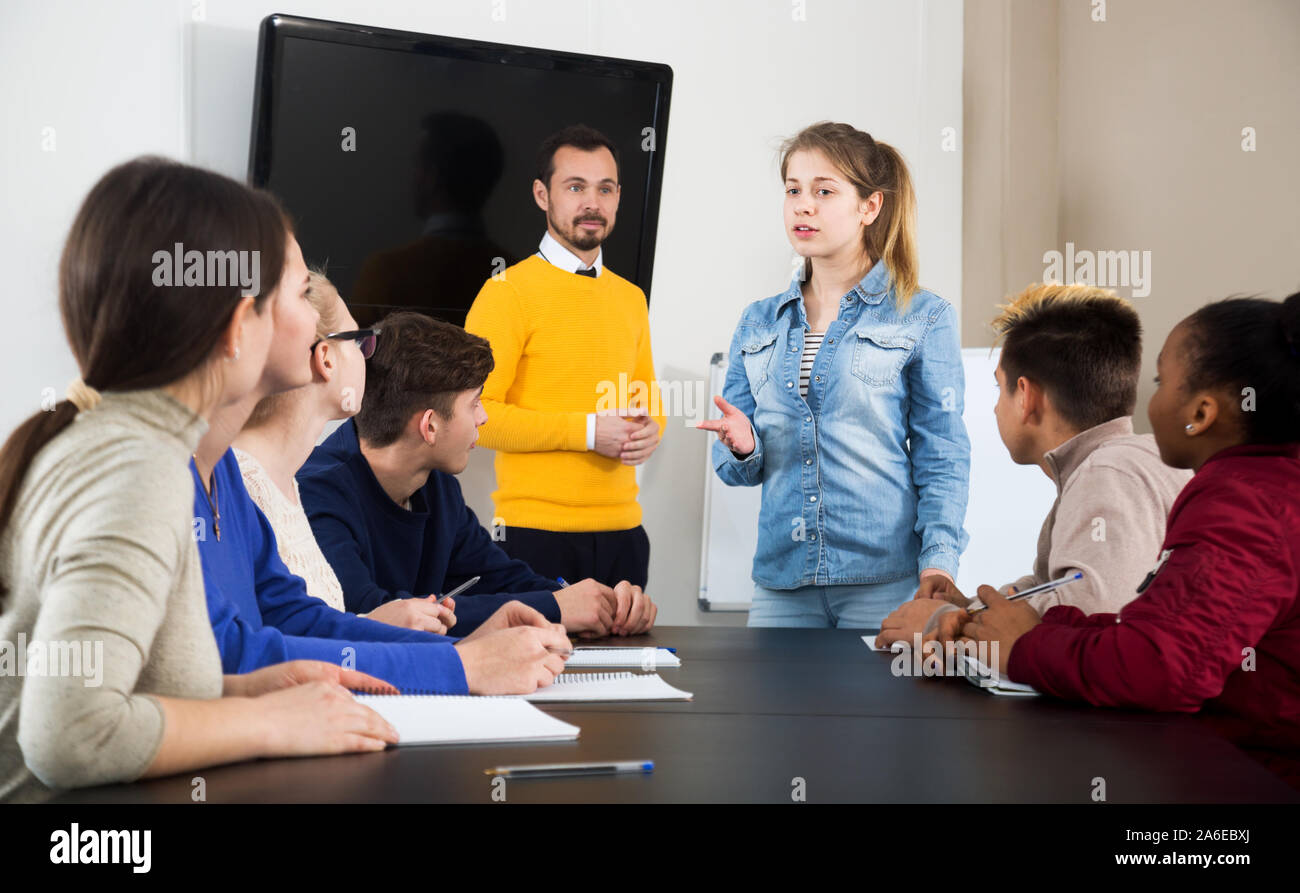 Smiling girl in class ready giving good answer to teacher’s question at ...