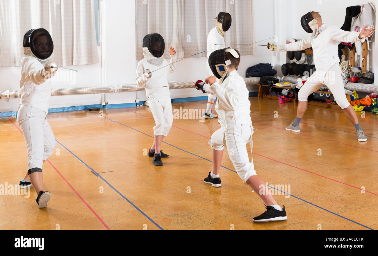 Group practicing effective fencing techniques in sparring in training ...