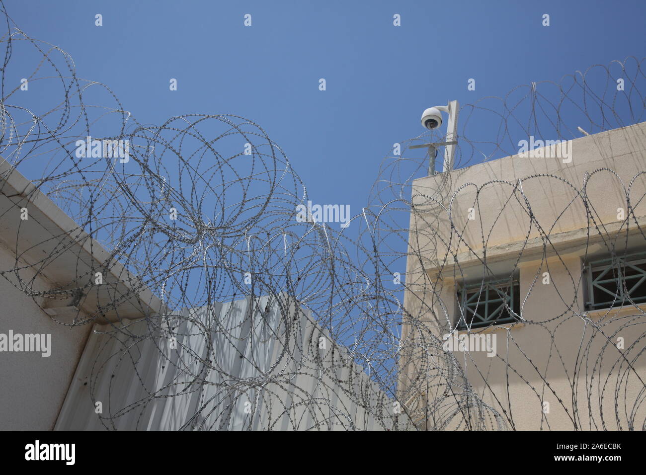 Security camera above barbwire in prison for supervision, security and ...