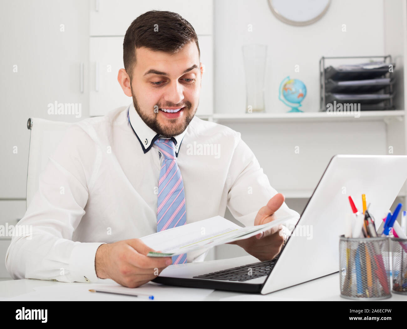 Positive male worker working effectively on project in office Stock ...