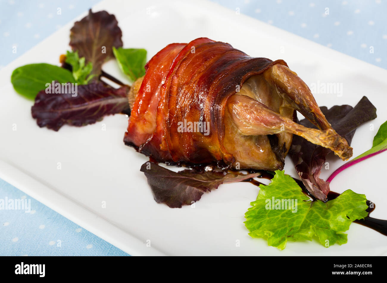 Baked in bacon quail with balsamic sauce is tasty dish in the kitchen ...