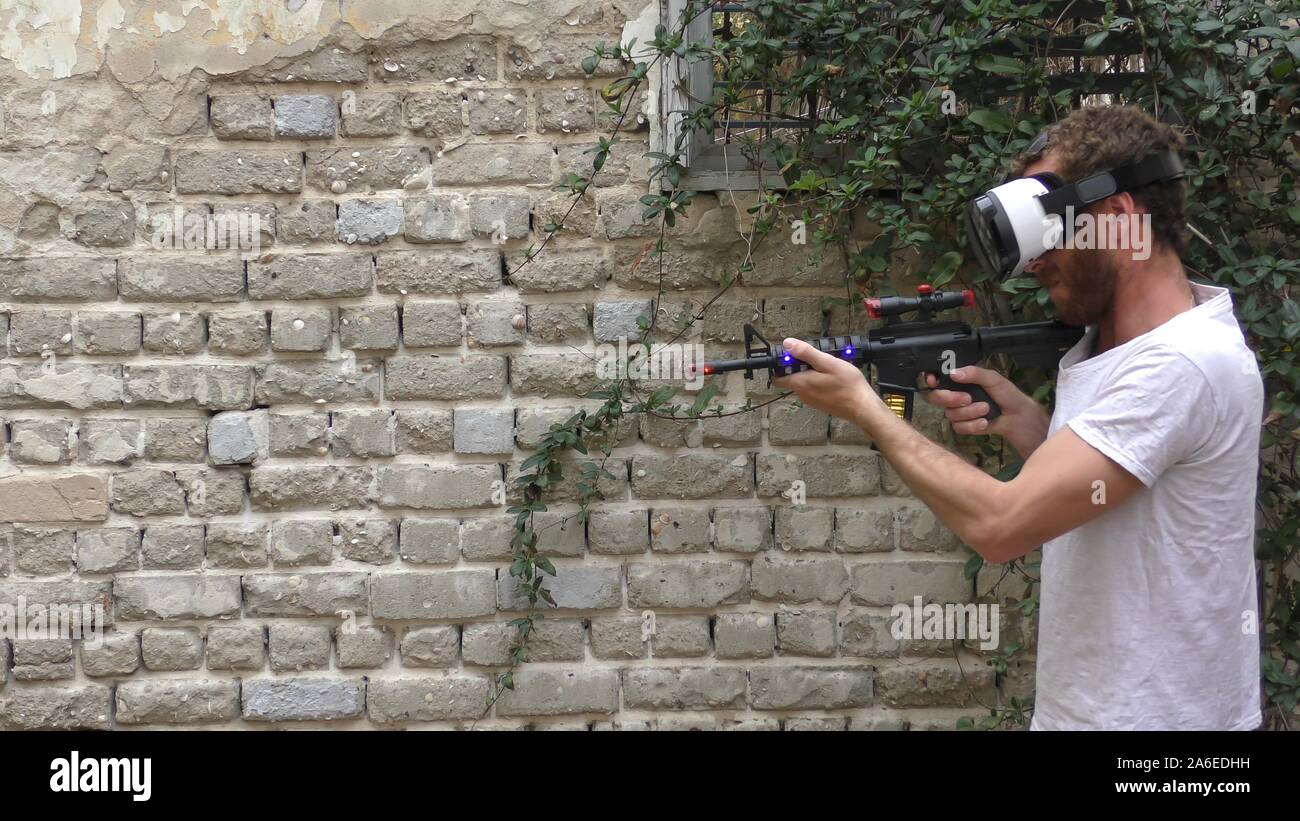 A man plays virtual augmented reality game using head mounted display ...