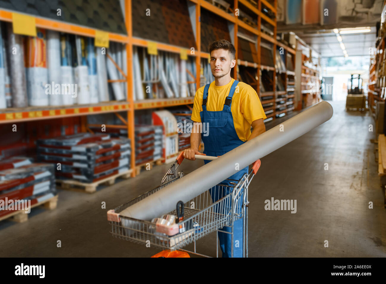 Male builder carries building materials in a cart Stock Photo - Alamy
