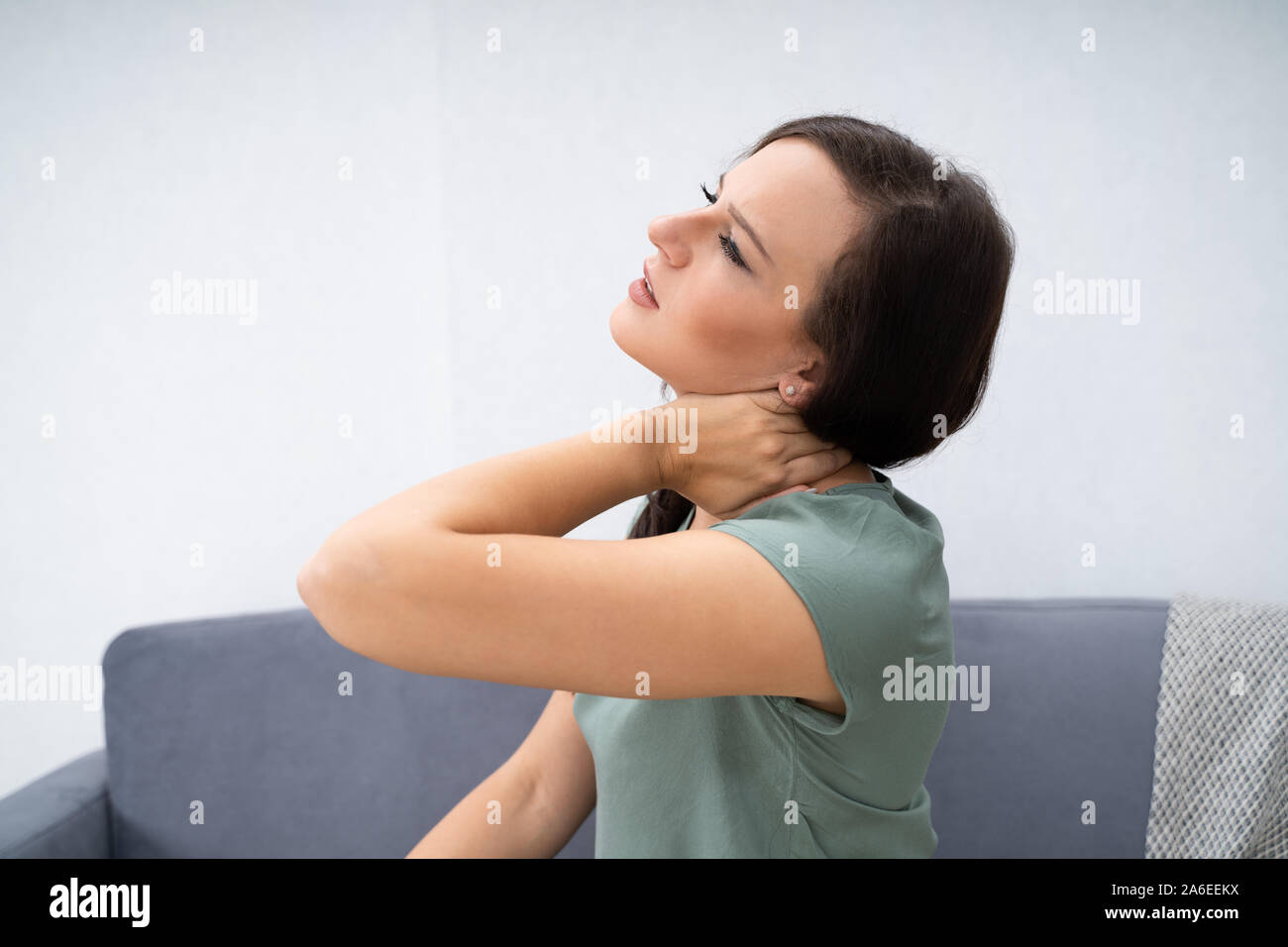 Woman Having Neck Pain Sitting At Home Stock Photo - Alamy