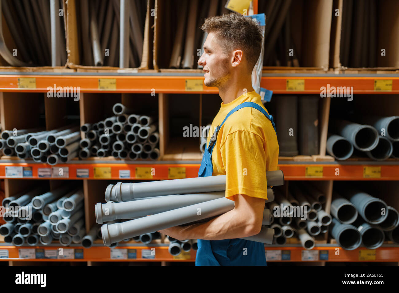 Male builder choosing piping in hardware store Stock Photo - Alamy