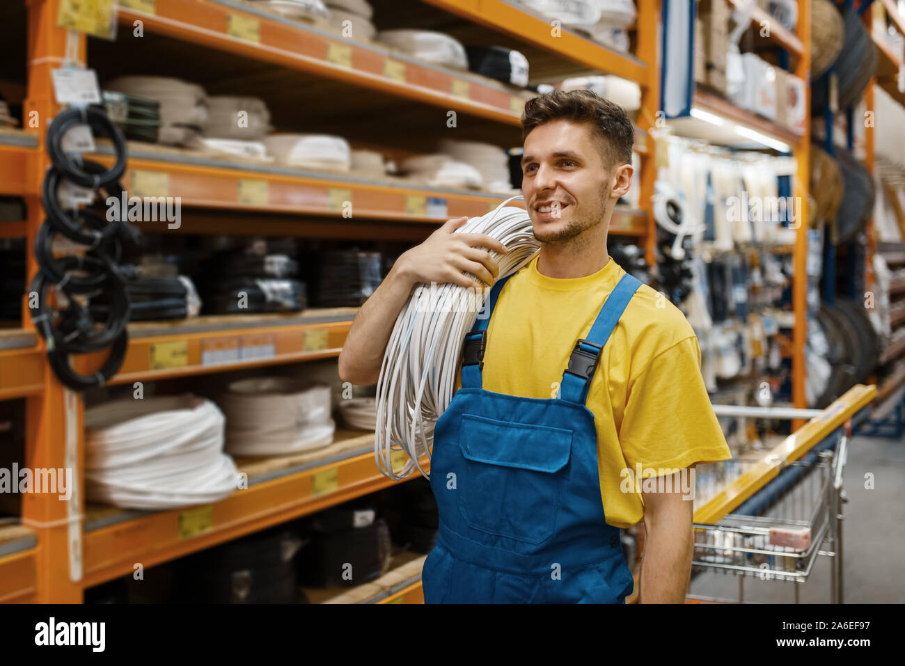 Male builder with coil of wires in hardware store Stock Photo - Alamy