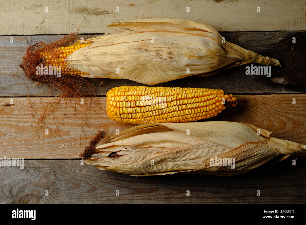 Still life of some corn cobs on old wooden background Stock Photo - Alamy