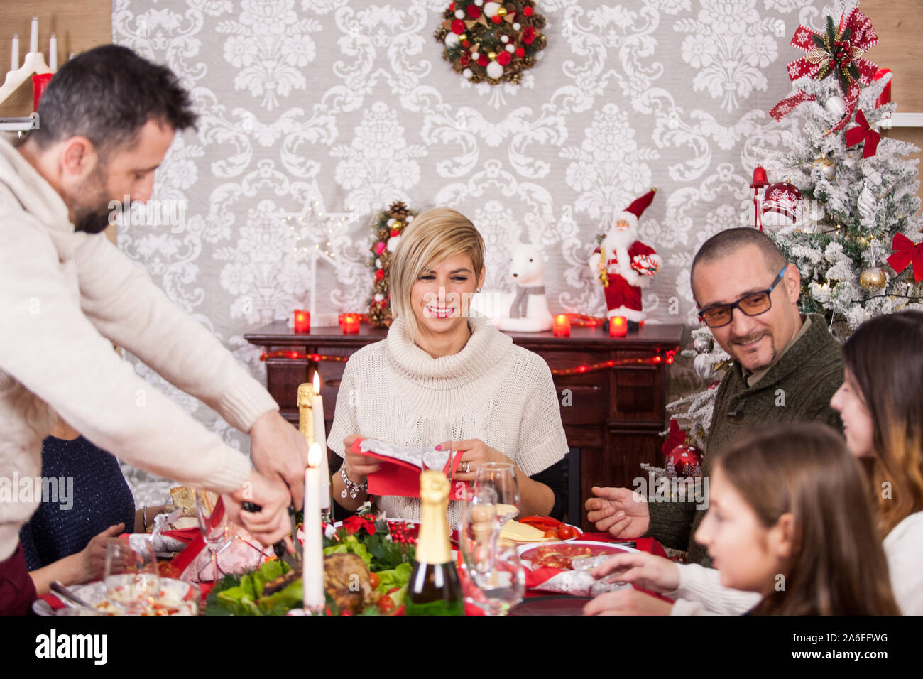 Portrait of beautiful family siting at christmas table and feeling good ...