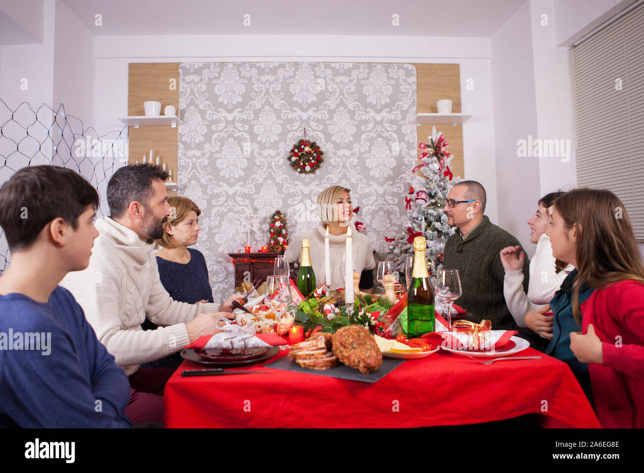 Cheeful family sharing moment at christmas feast. Christmas tree. Tasty ...