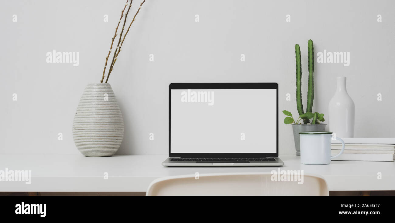 Minimal workspace with open laptop computer and decorations on white ...