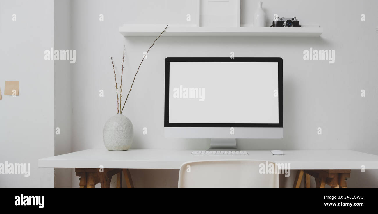 Modern workspace with blank screen desktop computer and decorations on white table and white ...