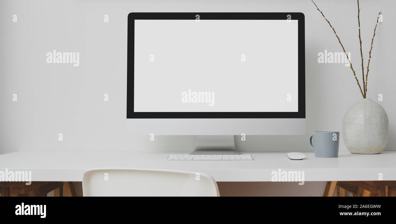 Modern workspace with blank screen desktop computer and decorations on white table and white ...
