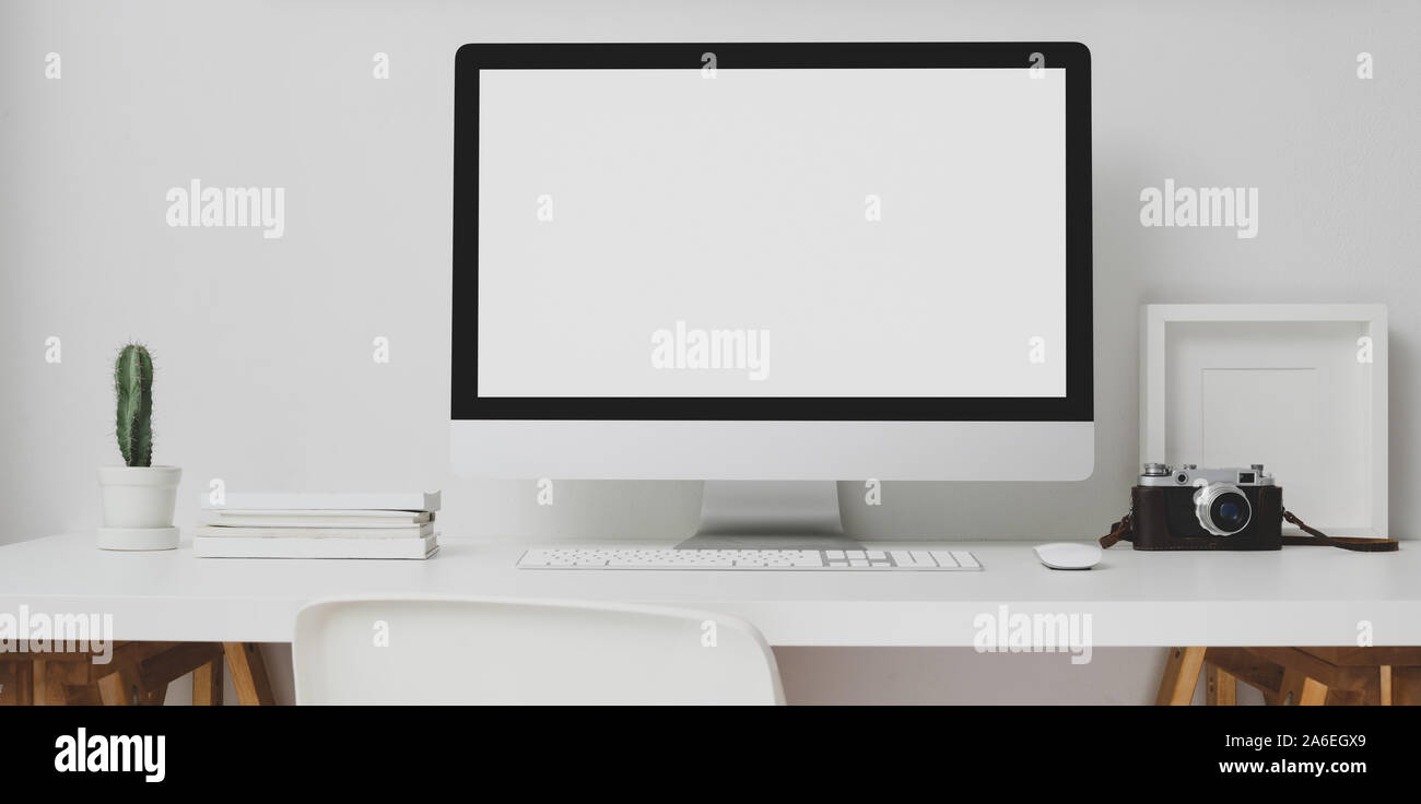 Modern workspace with blank screen desktop computer and decorations on white table and white ...