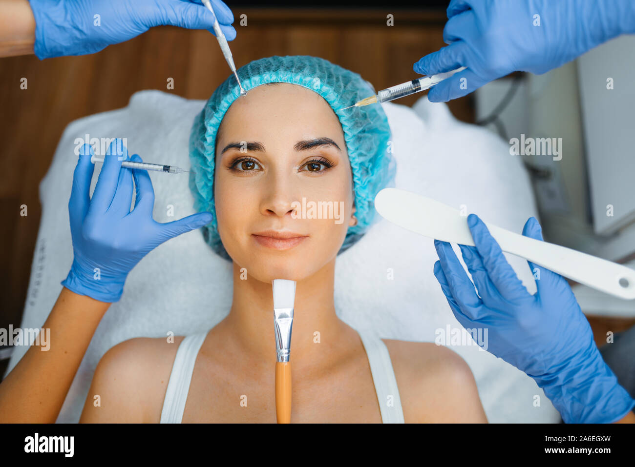 Cosmetician hands with working tools, patient face Stock Photo - Alamy