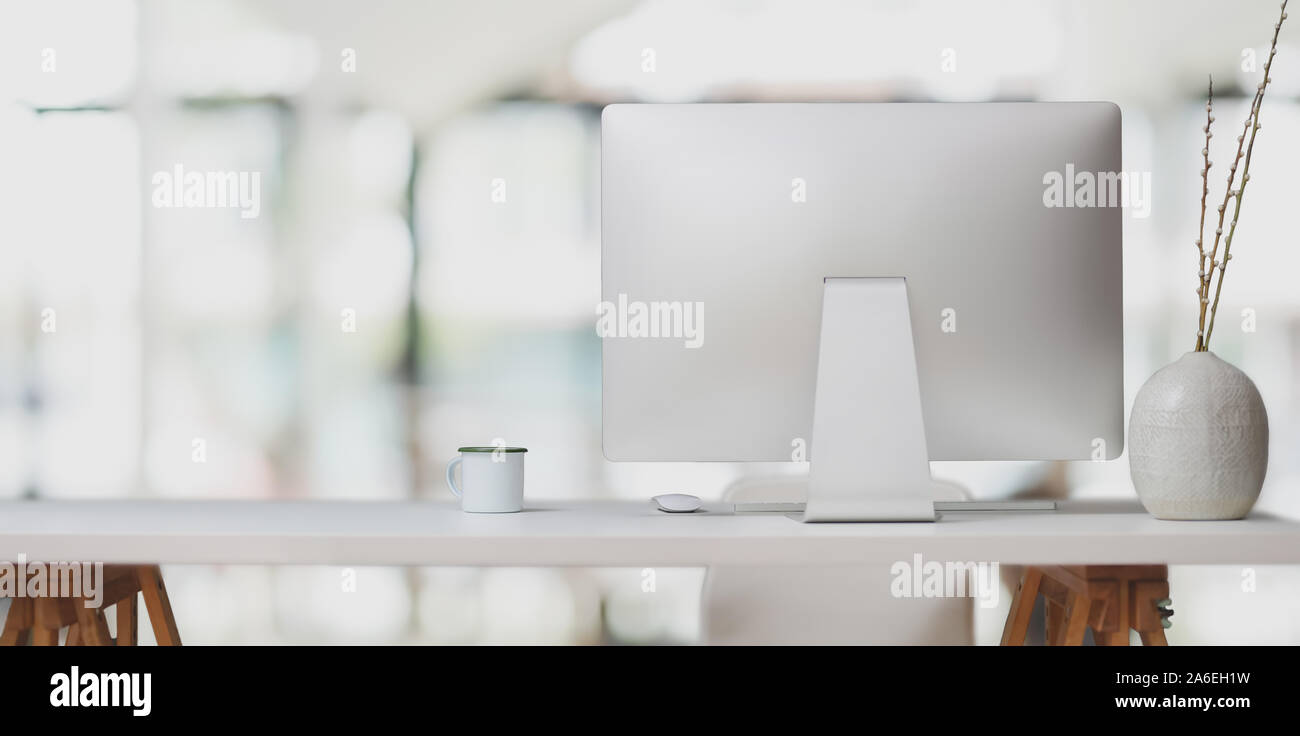 Desktop computer on white table and coffee cup in modern office room ...