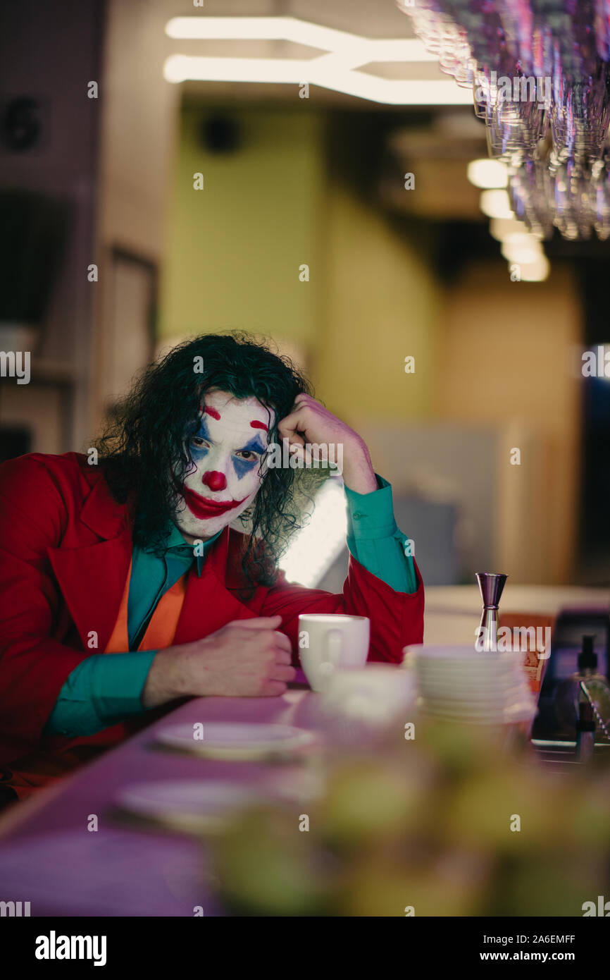 Cosplayer portrays a crazy clown against the background of the bar ...