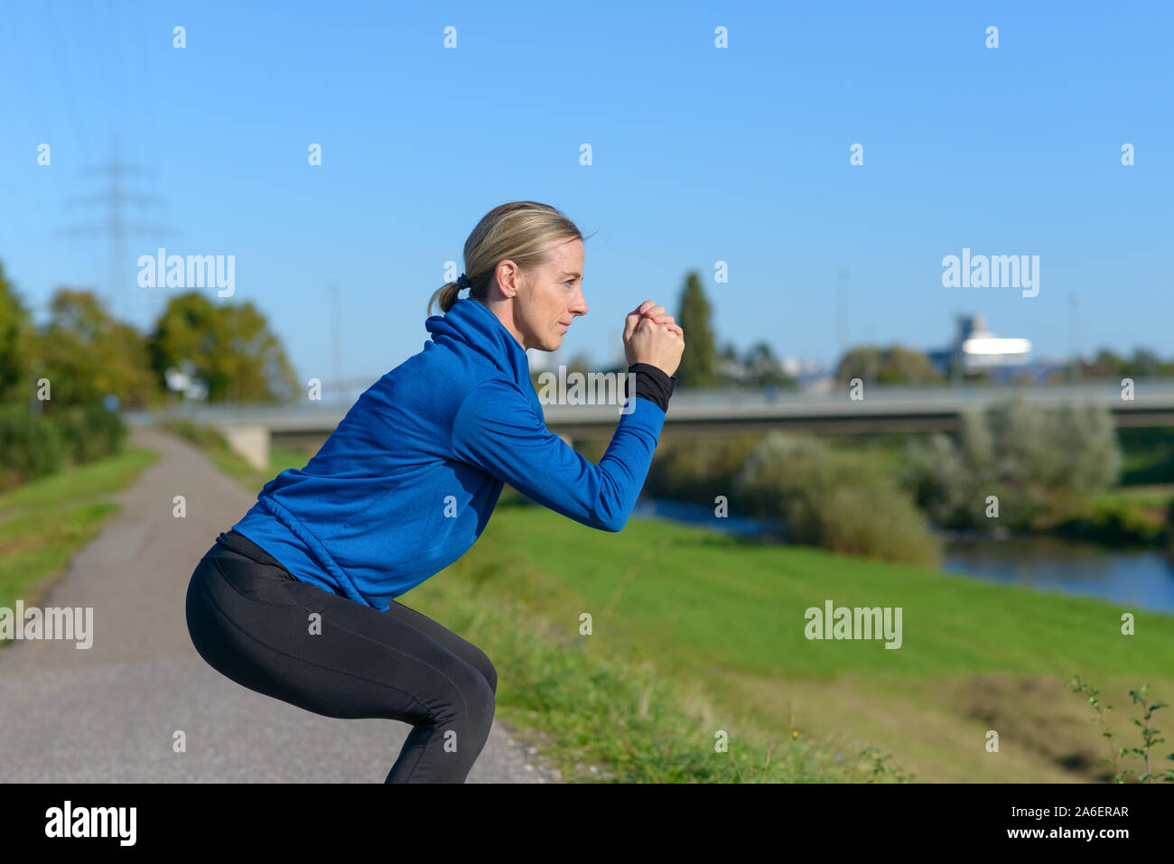 Close up of a fit woman doing crouch stretches to warm up her muscles ...