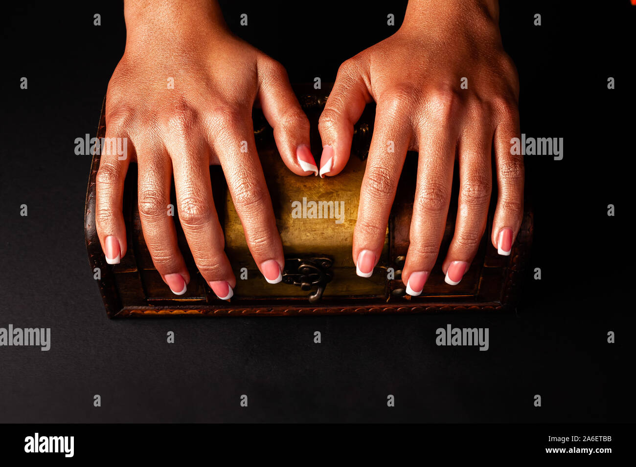 A beautiful female hand opens a chest. Beautiful french manicure Stock ...