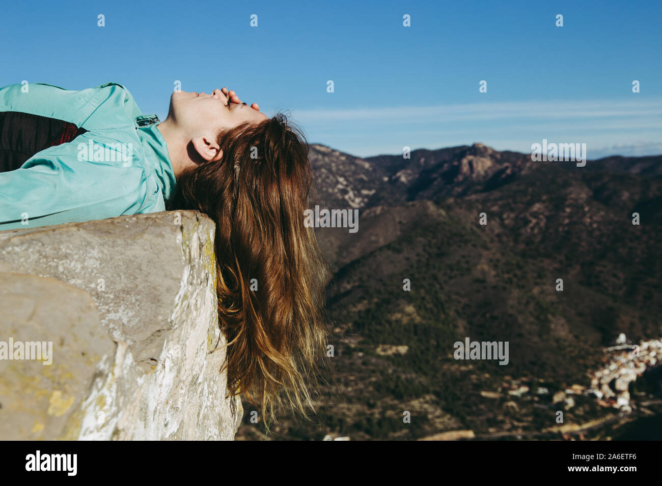 A young blonde woman is laying down and chilling out with her long hair ...
