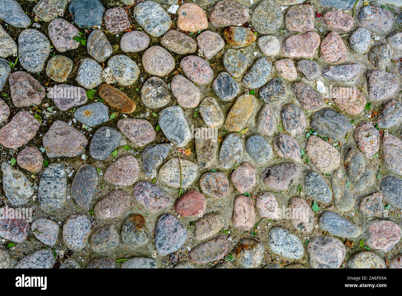 Stone background of pavement with rough granite boulders with little ...