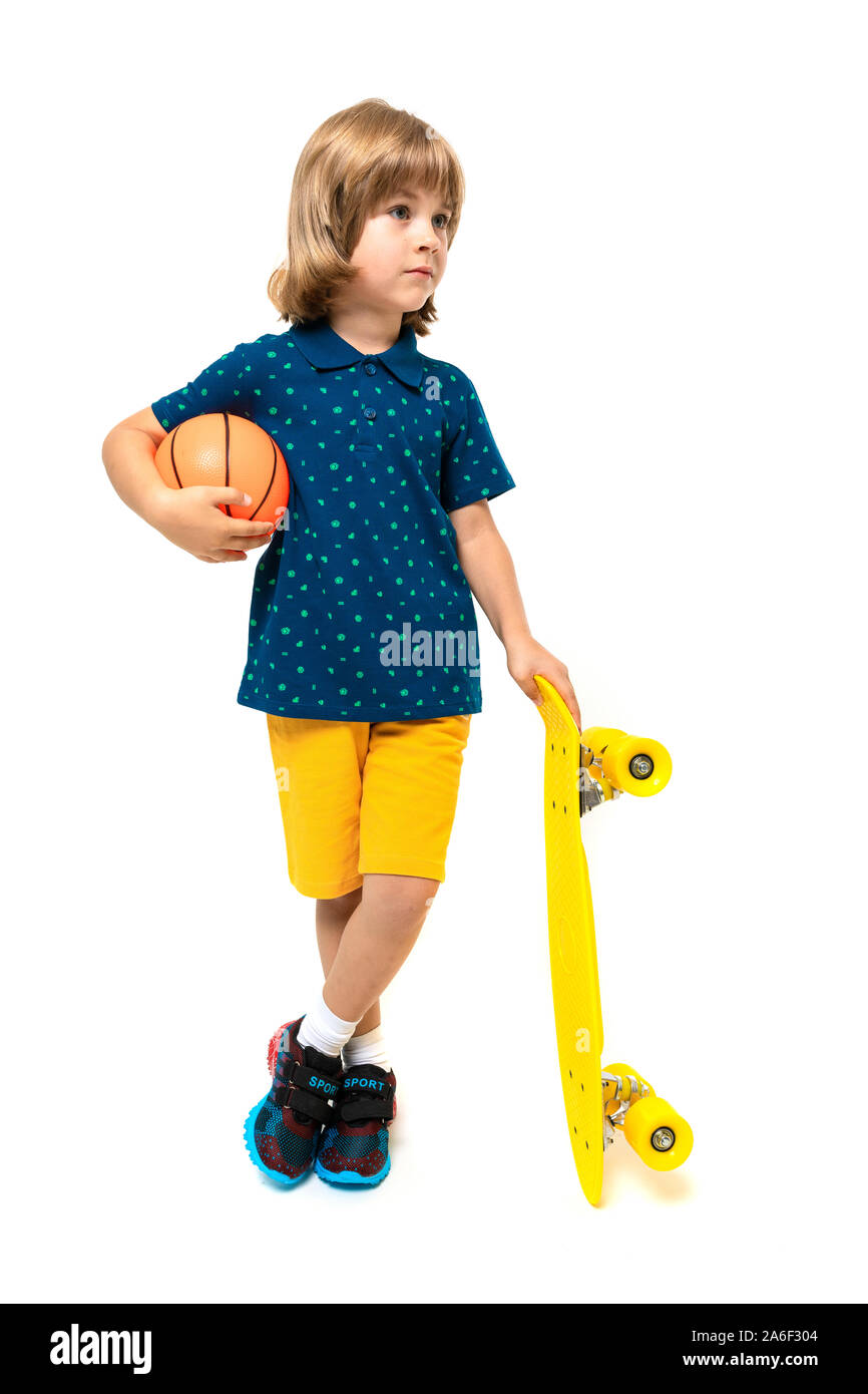 Picture of a teenage caucasian boy stands near yellow penny with ball ...