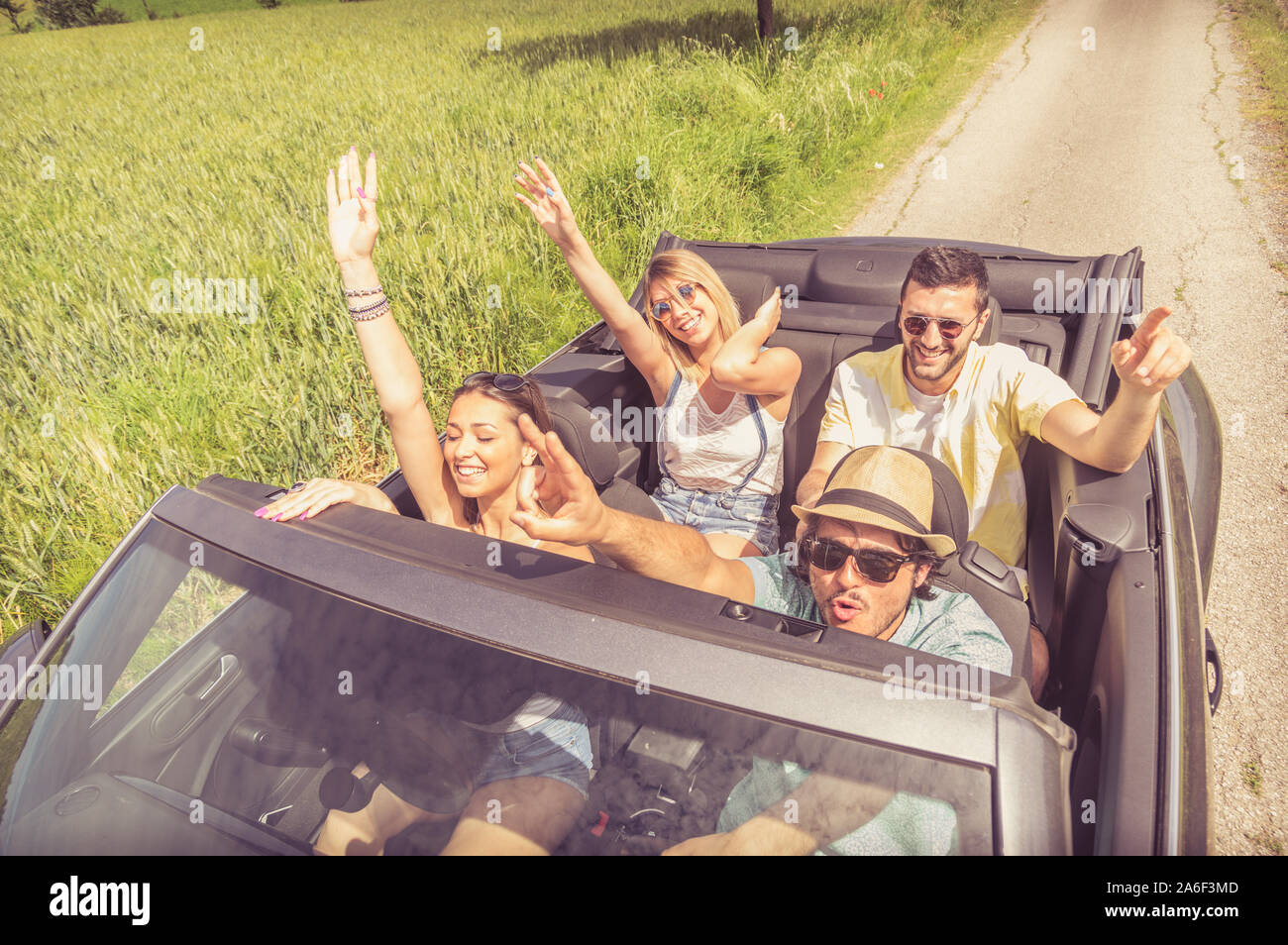 Group of friends having fun at car trip. Four caucasian people on a ...