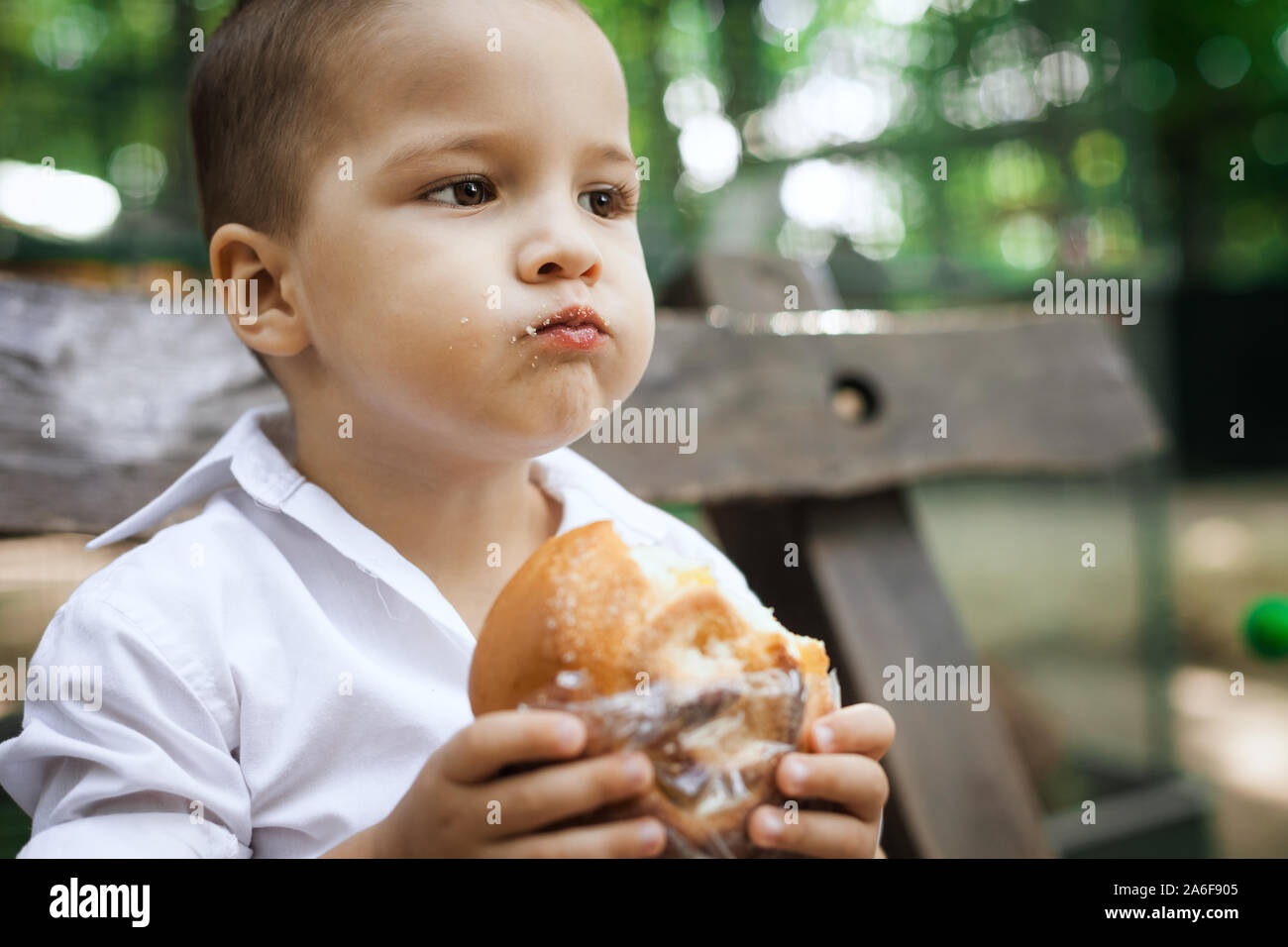 toddler boy eating a bun Stock Photo - Alamy