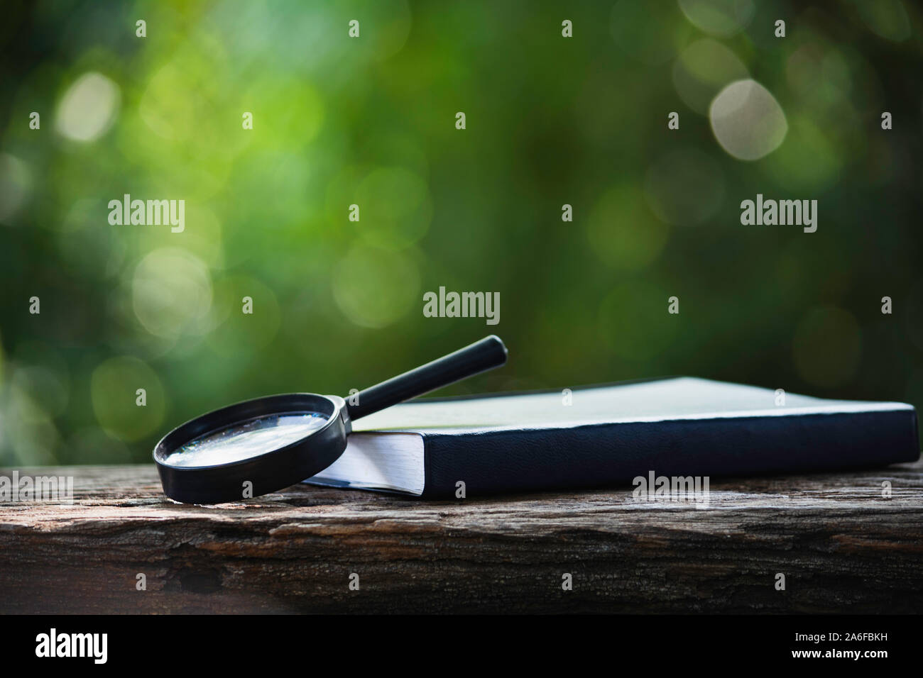 Magnifying glass and book on wooden table and copy space for insert ...