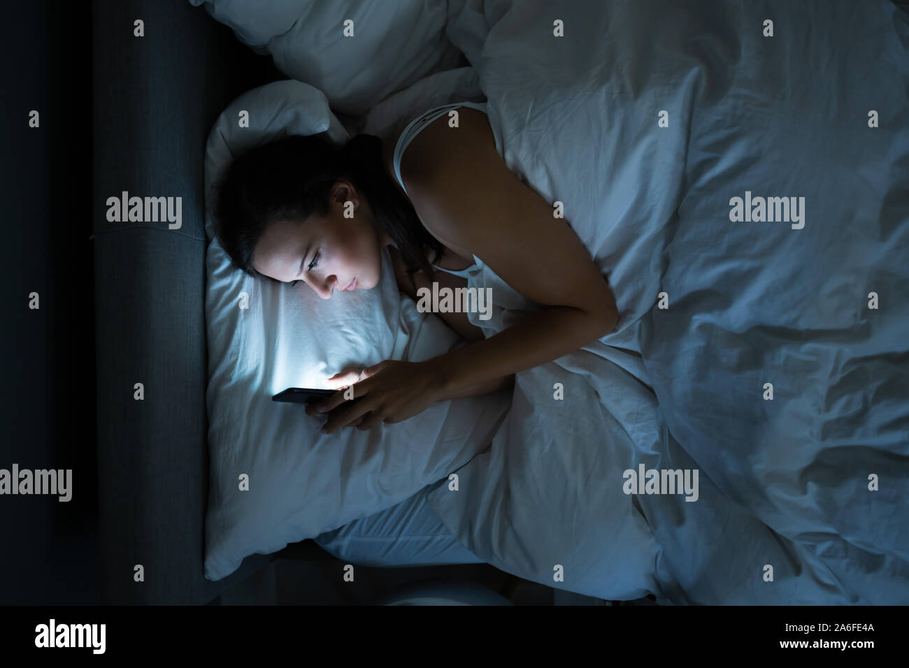 Woman In Bed With Mobile Phone At Night Stock Photo - Alamy