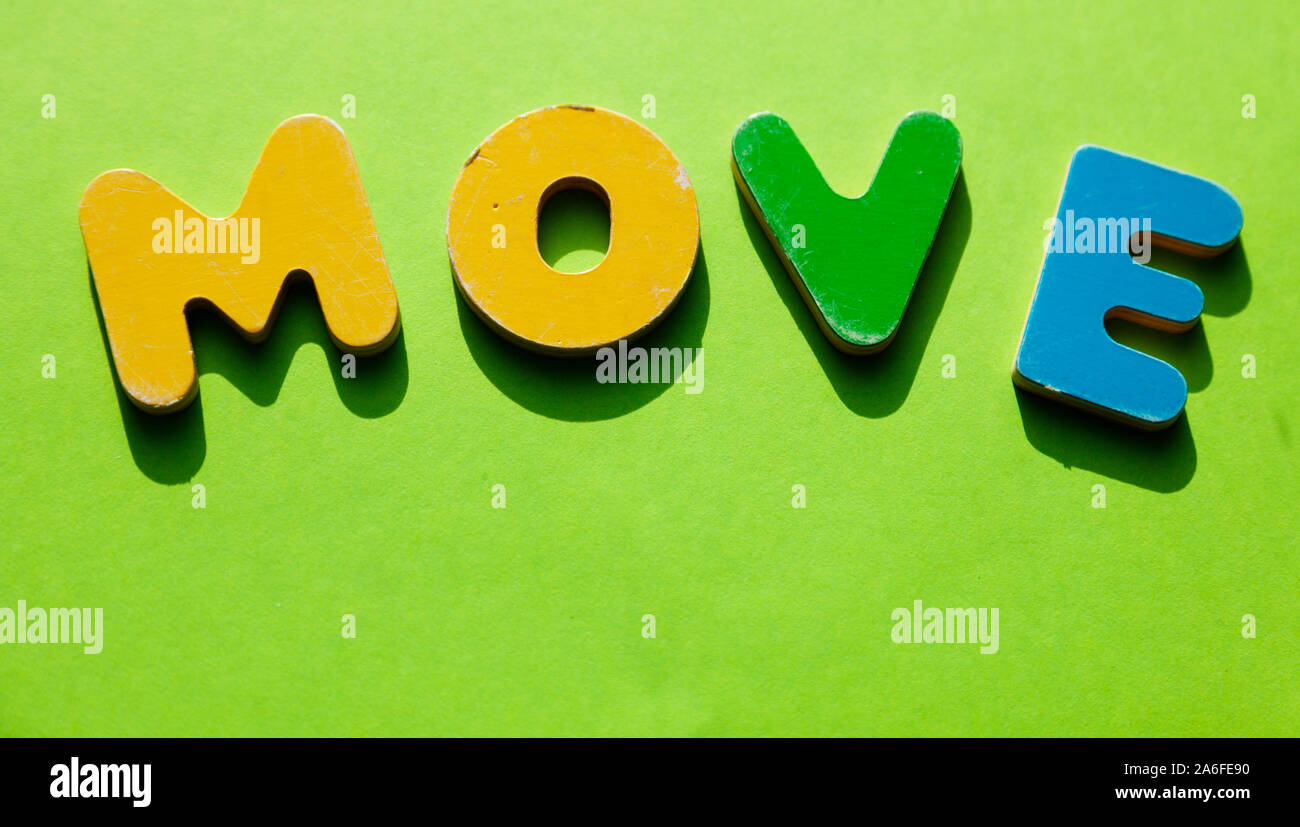 The Word MOVE In Wooden Letters On Light Green Background Stock Photo the-word-move-in-wooden-letters-on-light-green-background-stock-photo